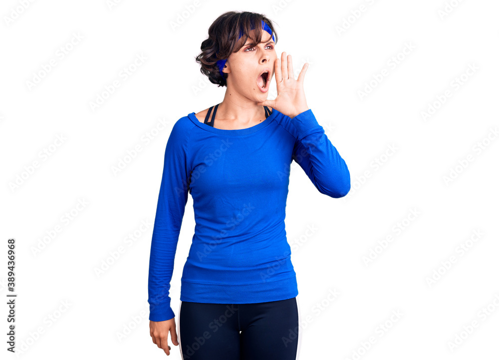 Beautiful young woman with short hair wearing training workout clothes ...