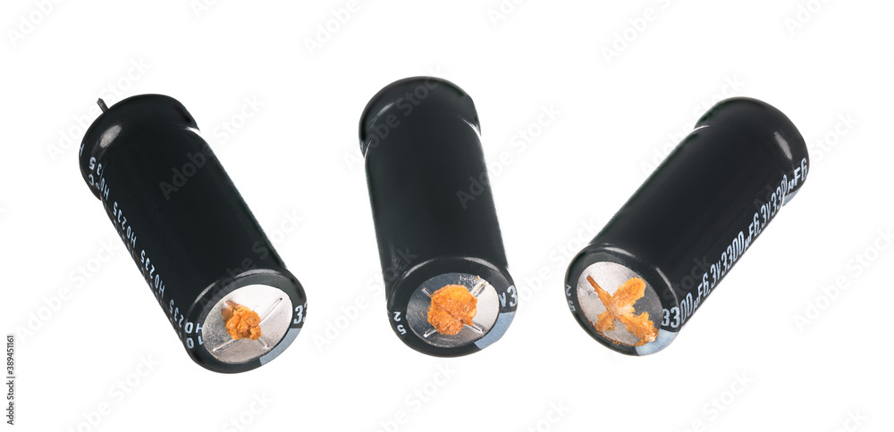 Damaged obsolete aluminium electrolytic capacitors isolated on white ...