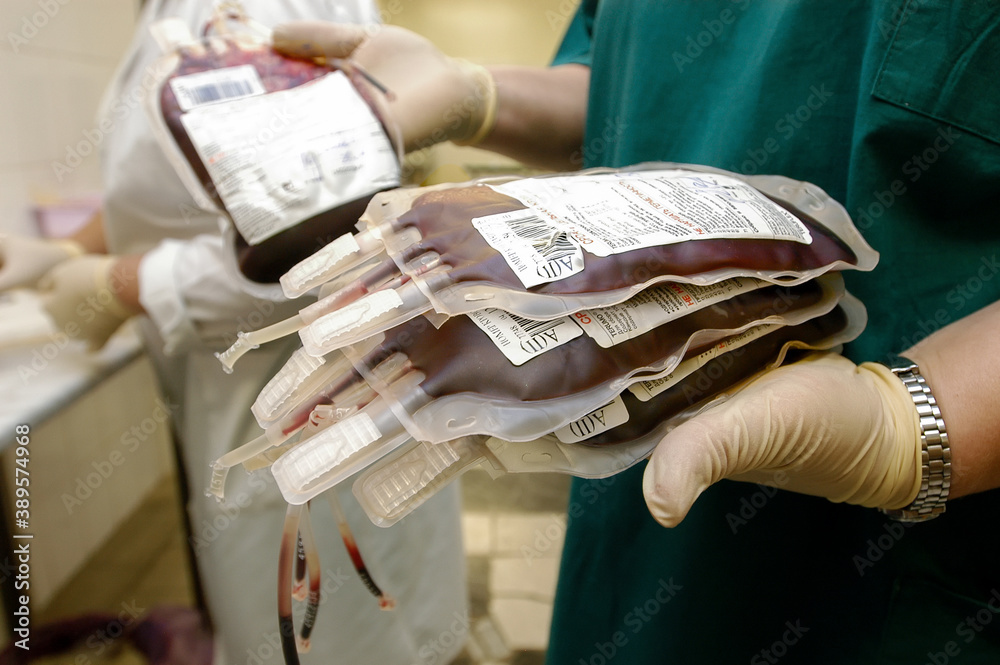 scientist's hand holds a red blood bag in the laboratory of a blood ...