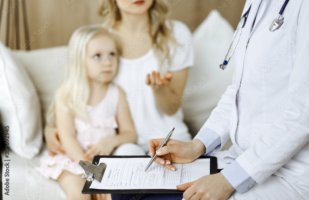 Doctor and patient. Pediatrician using clipboard while examining little ...