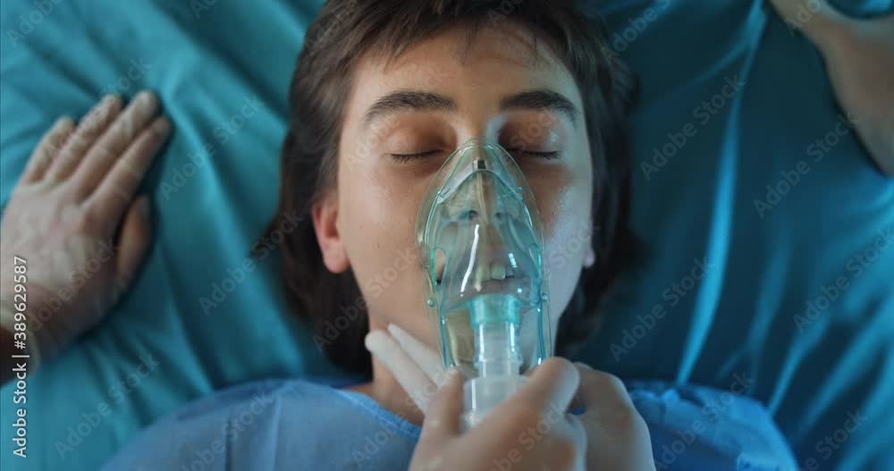 Paramedics Putting On Oxygen Inhalation Mask On Girl Face While Trying