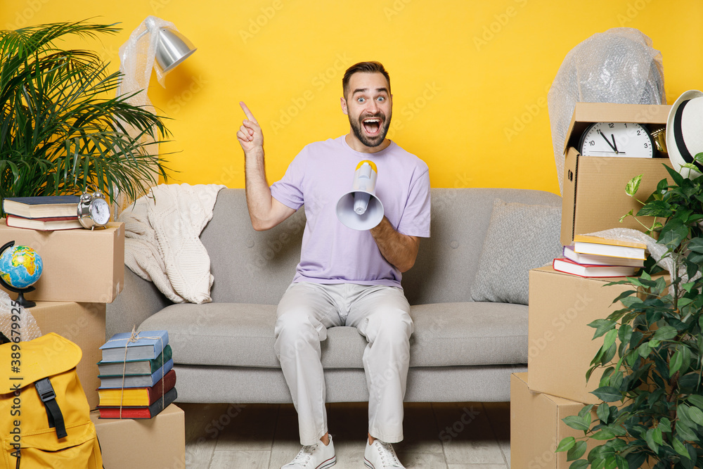 Excited young owner man scream in megaphone pointing aside up sits in ...