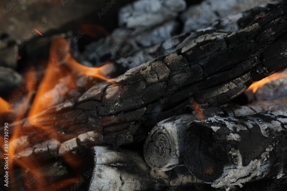 Smoldered logs burned in vivid fire close up. Atmospheric background ...