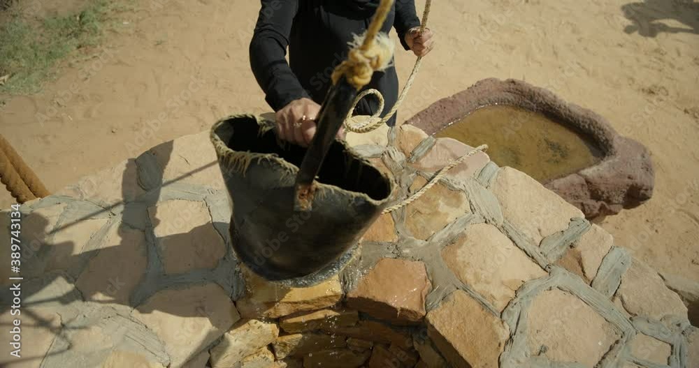 Tilt up, man picks up bucket from well in Saudi Arabia vídeo de Stock ...