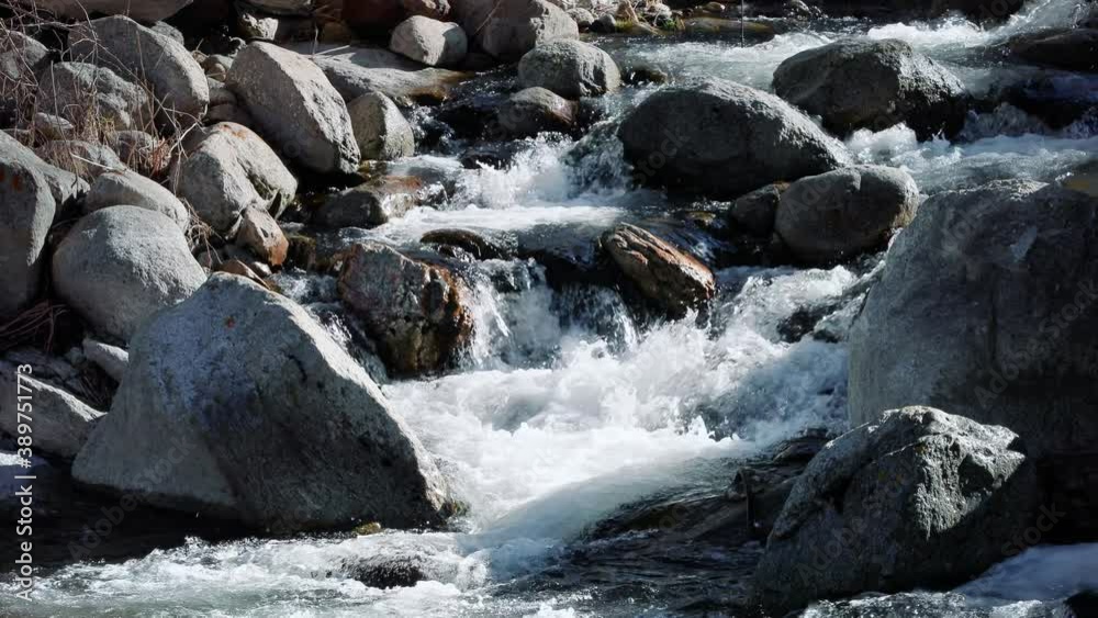 Stream with water flowing between rocks. Beautiful and relaxing view ...