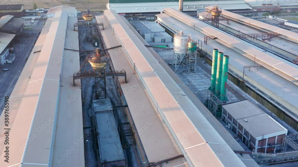 Long industrial halls in a metal factory with smokestacks, towers and ...