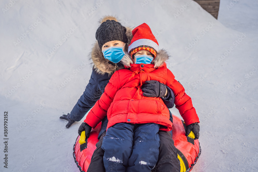 Foto de mom son ride on an inflatable winter sled tubing wear medical ...