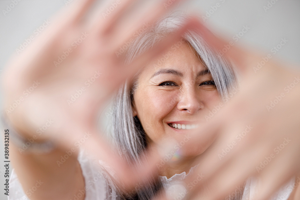 Emotional portraits of a paled long hair asian matured woman on grey ...