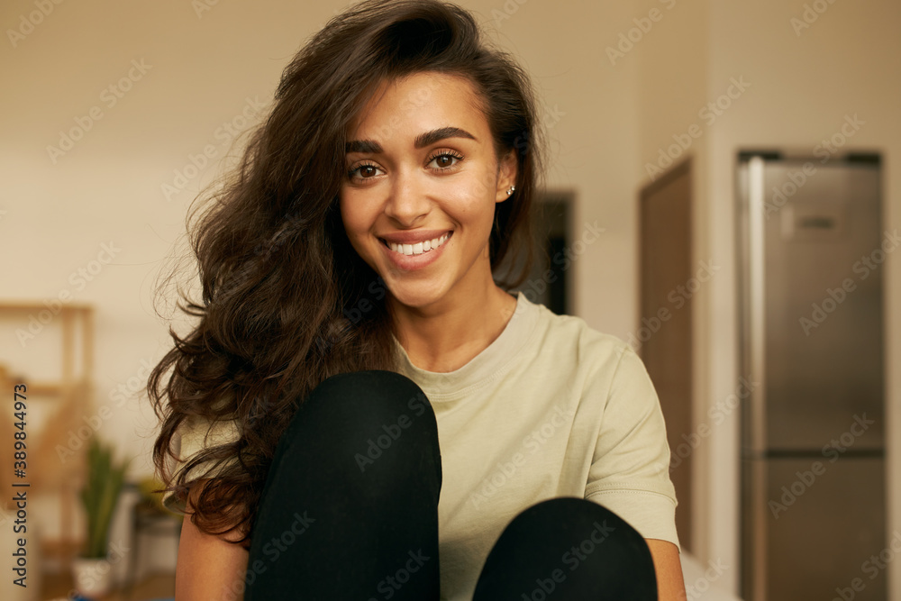 Indoor shot of beautiful happy young 20 year old Arabic woman relaxing ...