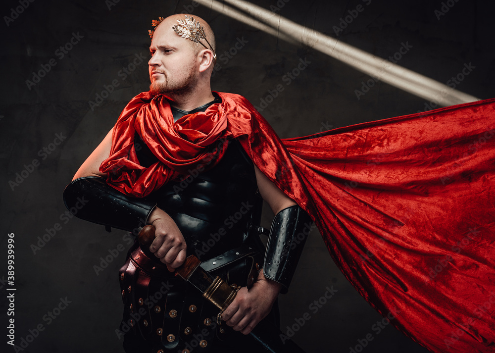 Bald and handsome roman soldier dressed in black armour with wreath on ...