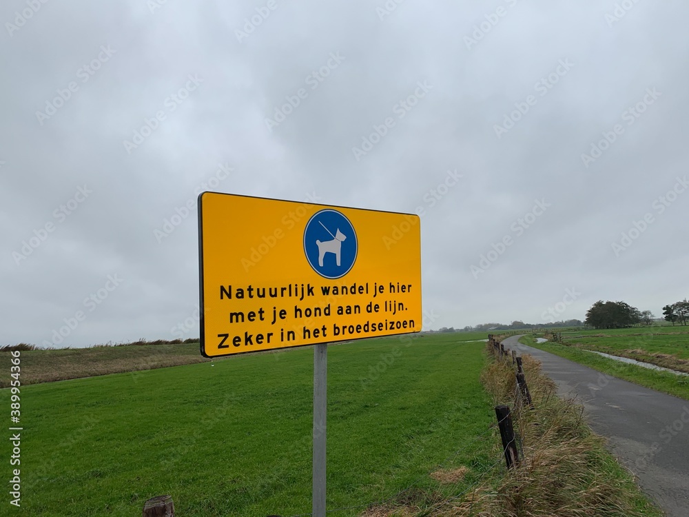 Foto de Road sign in Dutch language. Walk your dog with the leash here ...