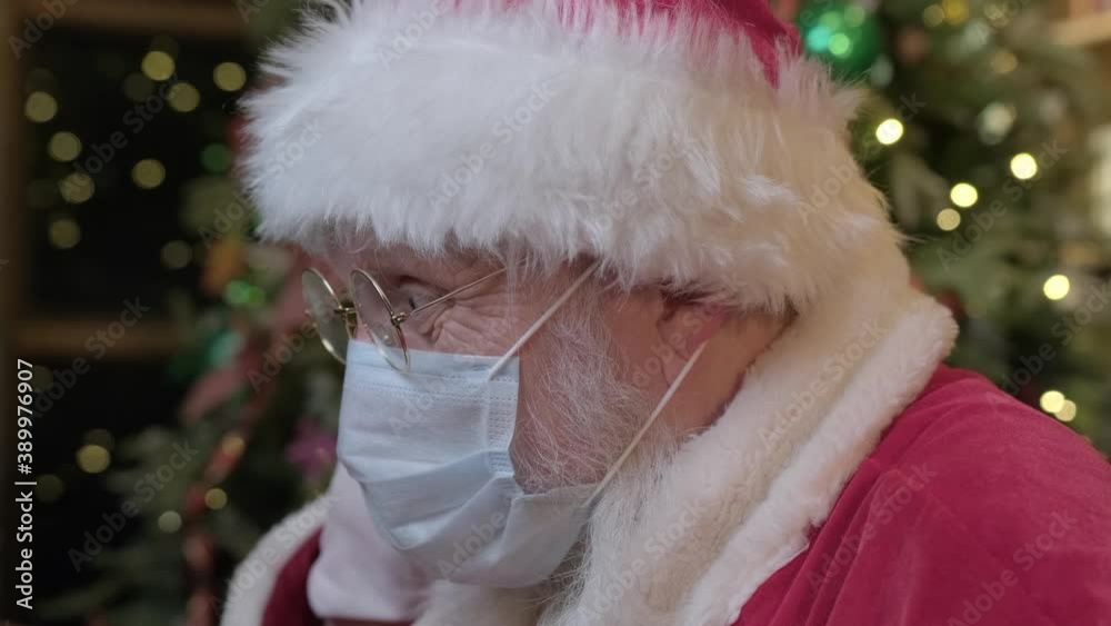 Tired Santa Claus removes medical mask from his face and exhales air ...
