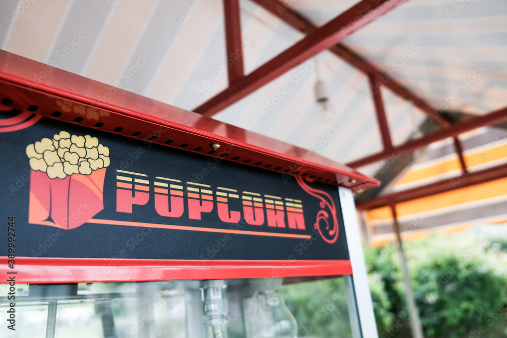 Popcorn booth signboard. Buying popped corn for a romantic evening date ...