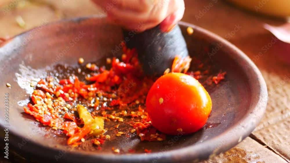 Making sambal with mortal and pestle. Sambal is Sambal is an Indonesian ...