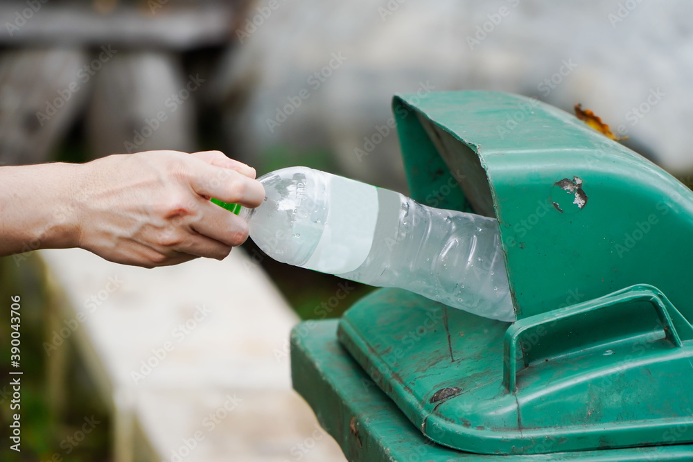 Woman hand throwing away plastic bottles in nature Environmental damage ...