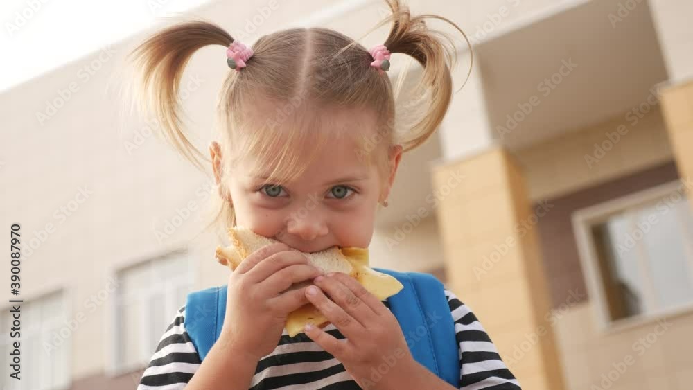 schoolgirl eating a sandwich during recess in school. lifestyle kids ...