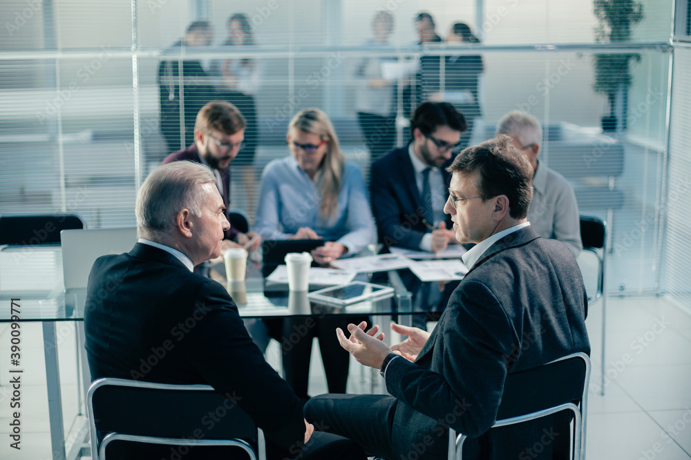 business colleagues discussing serious issues at an office meeting ...