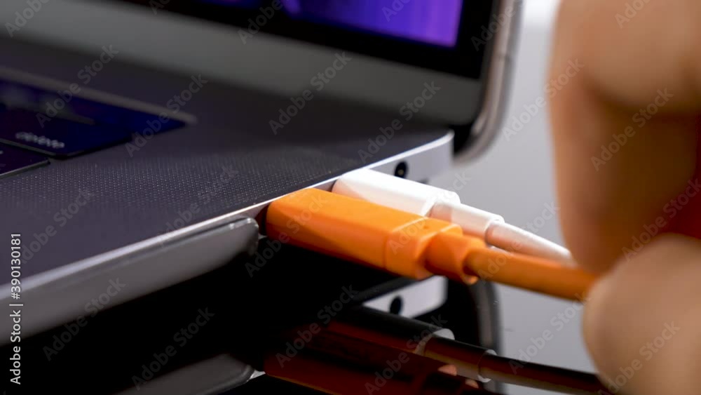 Close-up shot of hand inserting USB Type C wire into laptop computer on ...
