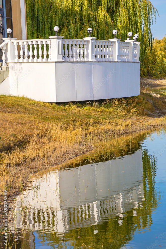 Beautiful white terrace with parapet and lanterns on the river ...