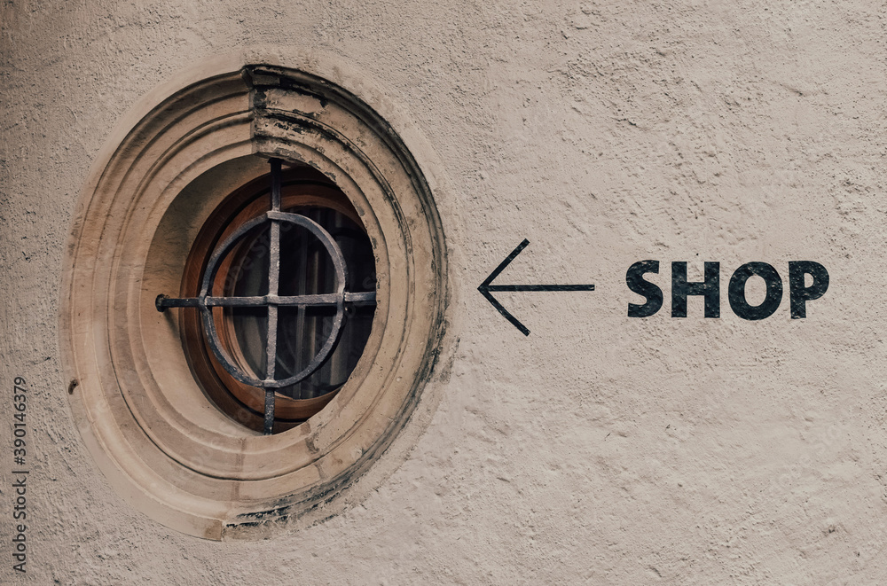 Old round window with metal grate in the wall and a pointer with an ...