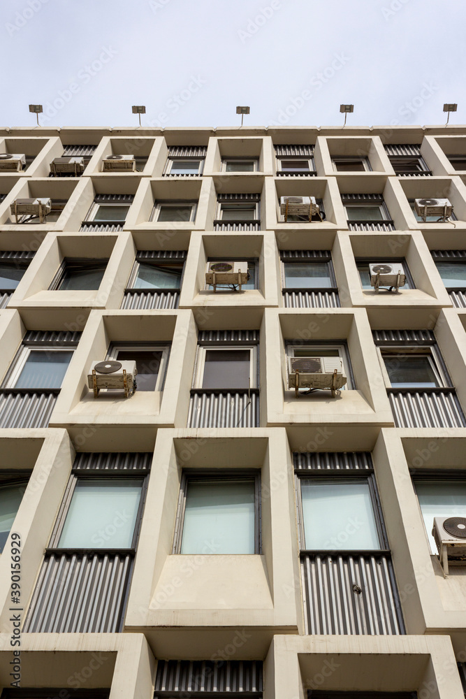 A modern building with a yellow facade and lots of air conditioners ...