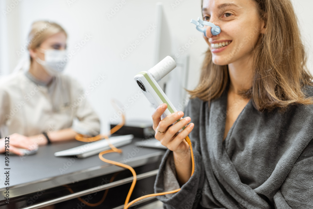 Young woman with doctor during a spirography test, measuring breathing ...