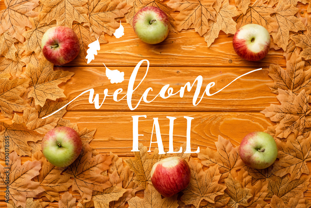 top view of ripe apples and leaves near welcome fall lettering on ...