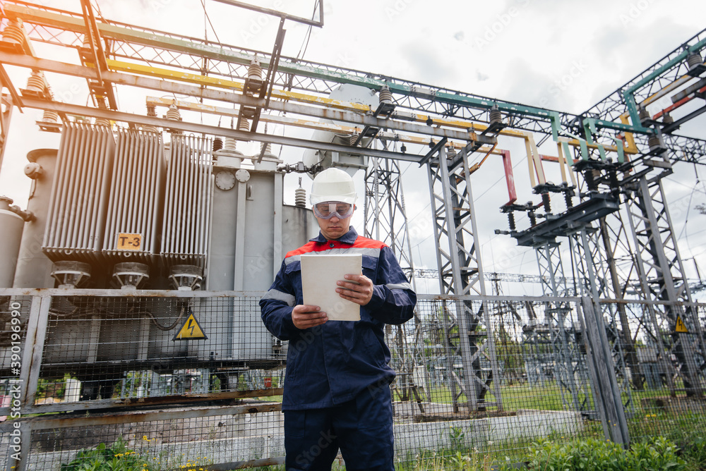 The energy engineer inspects the equipment of the substation. Power ...