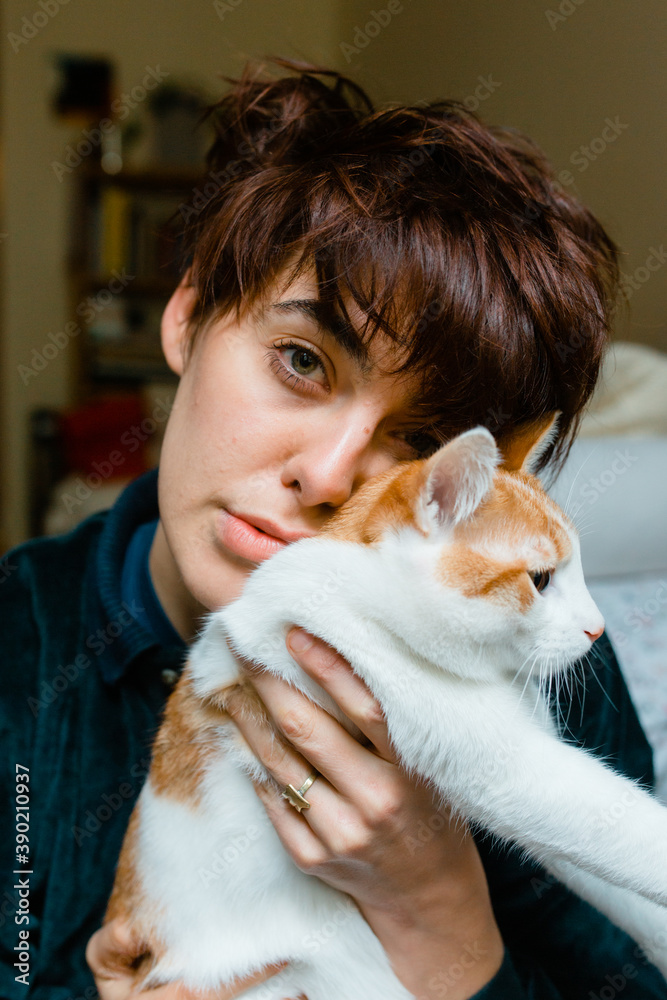 portraits of young short-haired woman in her house with her beloved cat ...