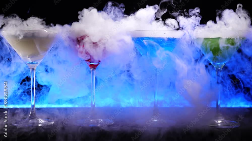 Various colorful cocktails with dry ice at bar counter close up ...