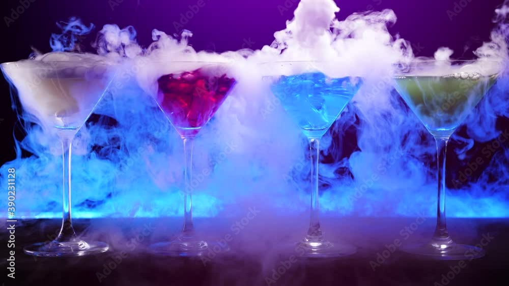 Various colorful cocktails with dry ice at bar counter close up ...