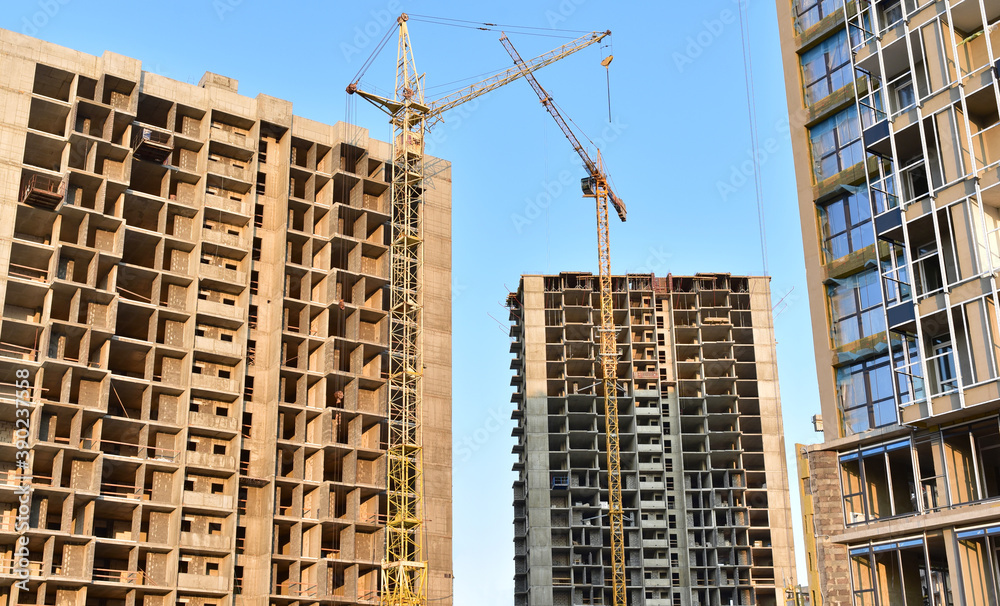 Tower cranes in action at construction site. Construction of skeleton ...