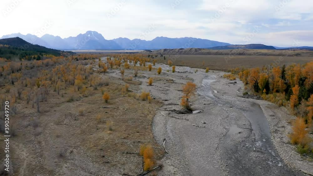 Aerial-Flying downstream over Spread Creek, a shallow stream in a wide ...