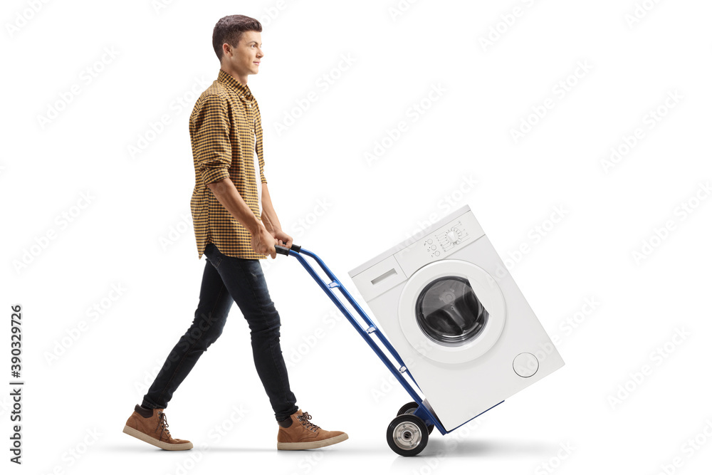 Full length profile shot of a young casual man walking and pushing a ...