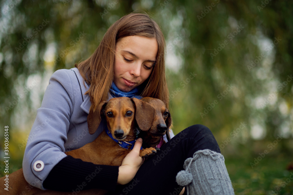 Smiling lady taking free time with her dog. Woman relaxing in the ...
