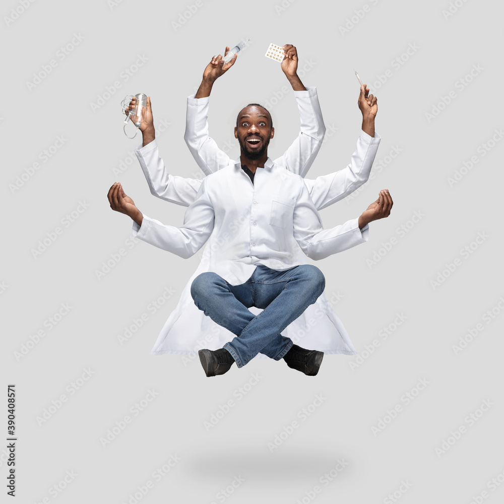 Handsome african doctor, multi-armed man levitating isolated on grey ...