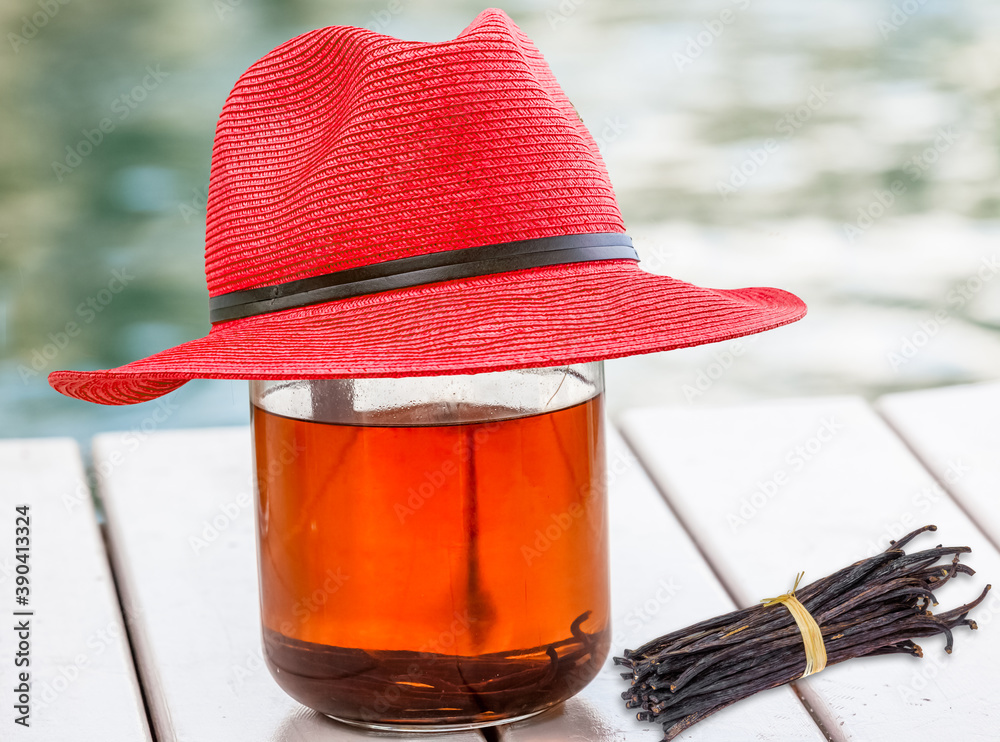 Chapeau de paille rouge sur bonbonne de punch des îles parfumé à la ...