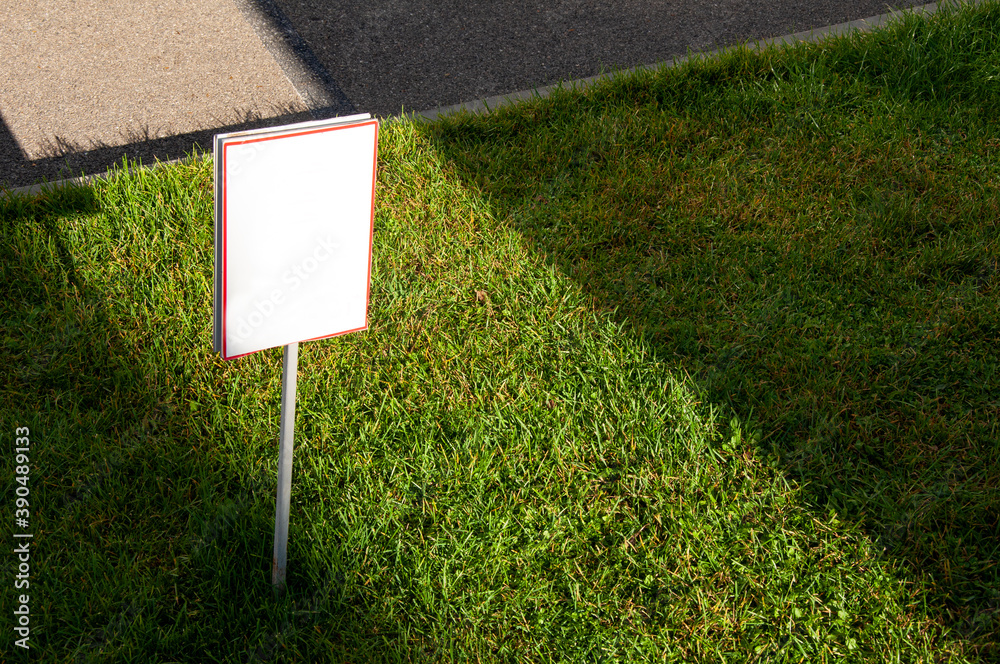 warning sign with green lawn and asphalt background, view from above ...