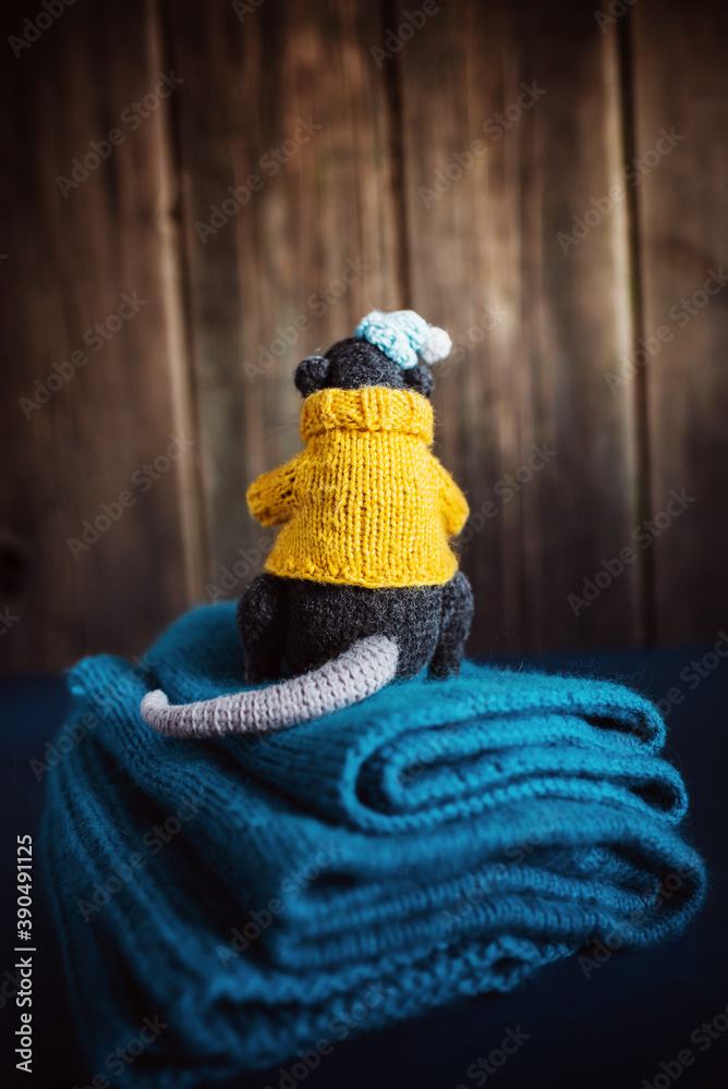 Handmade knitted toy. Amigurumi black rat toy in blue hat and yellow ...