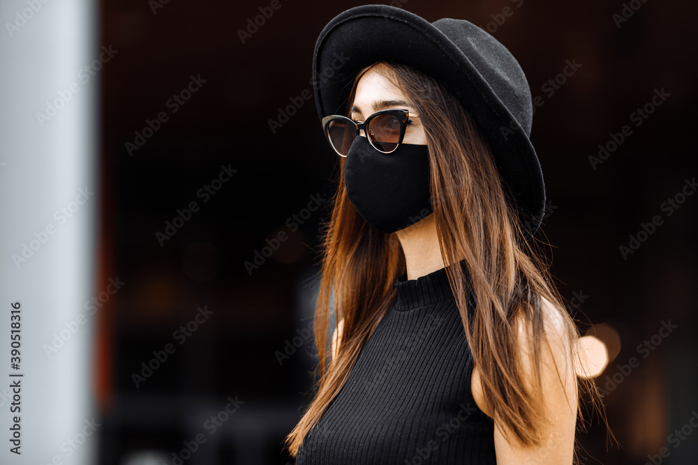 beautiful stylish girl in a black medical protective mask on her face ...