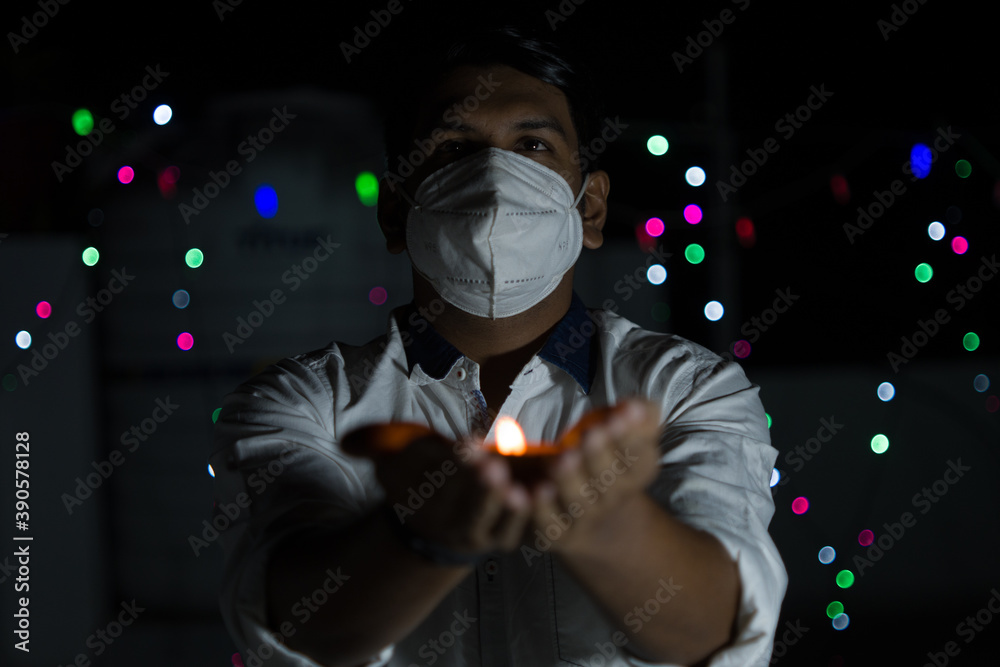 Young man celebrating diwali festival with medical mask and diya(oil ...