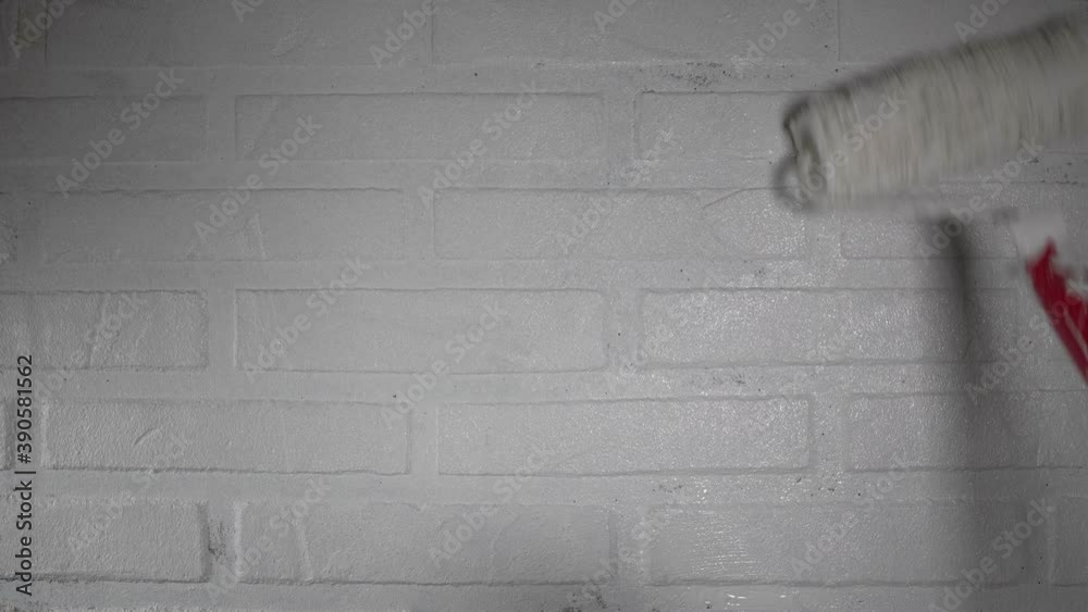 paint the brick-decorated wall with a roller with white paint ...