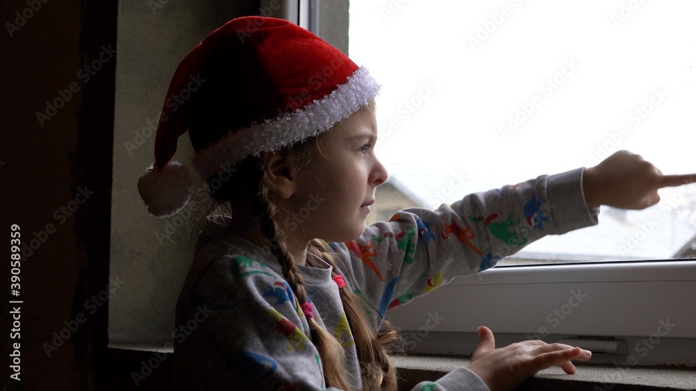 Little girl by the window in Santa hat. Orphans and Christmas ...