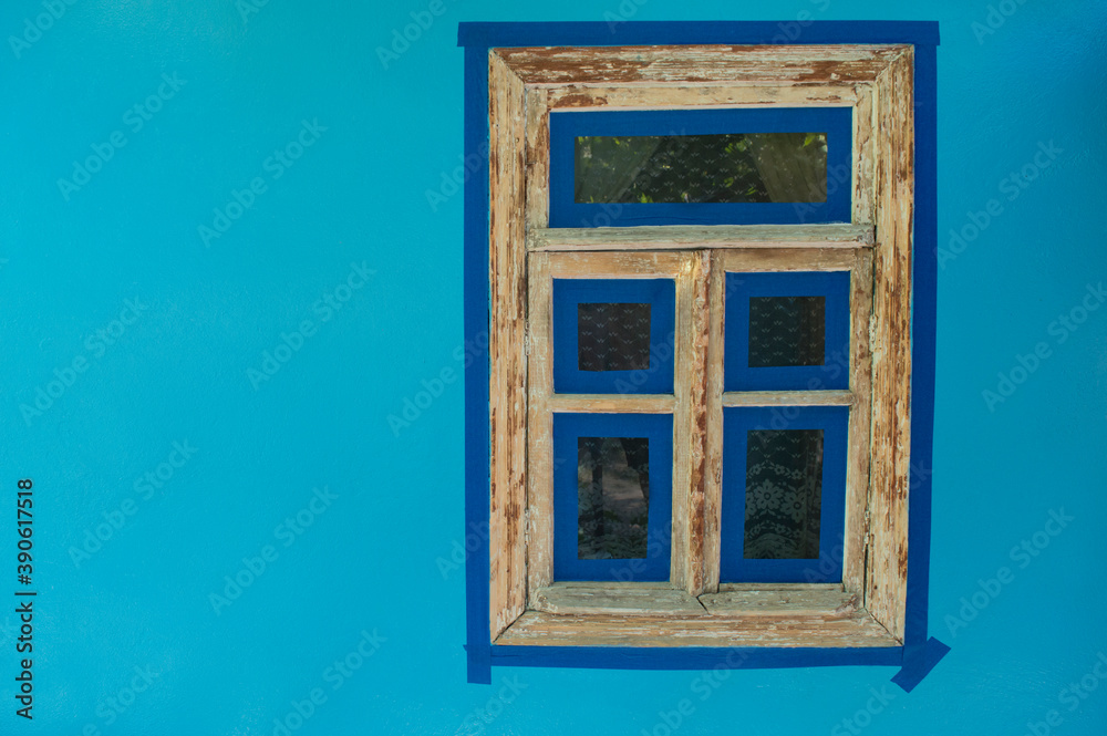 Using masking tape to prepare an old wooden window frame for painting ...