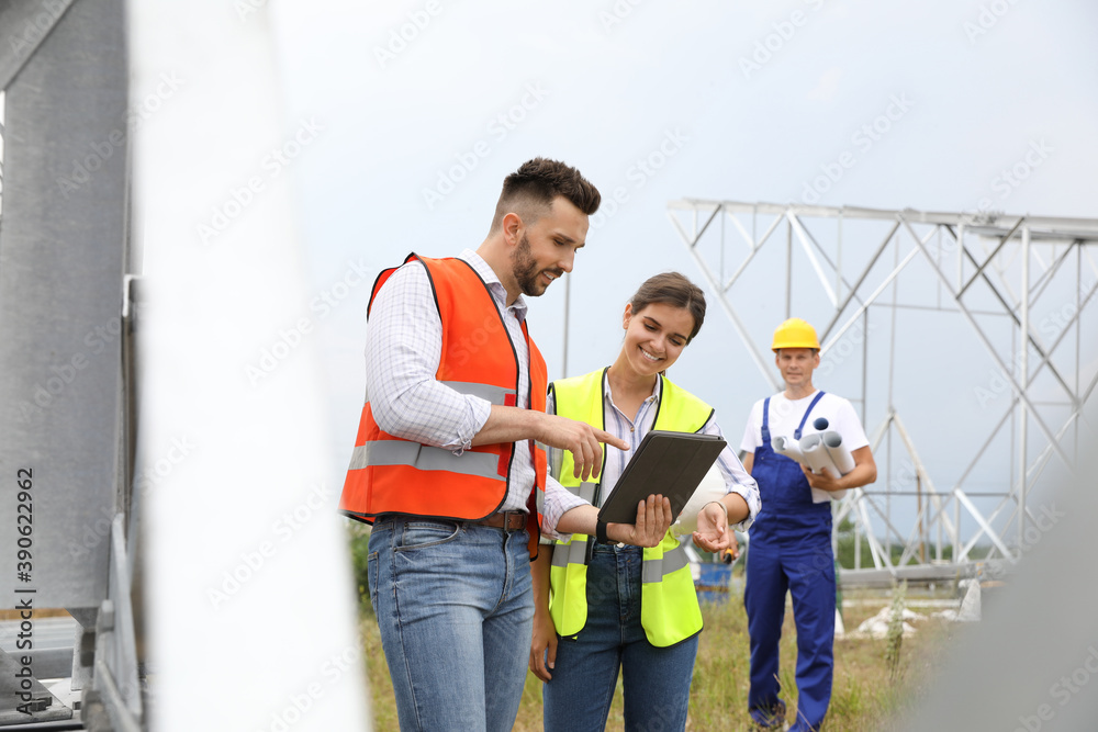Professional engineers working on installation of electrical substation ...