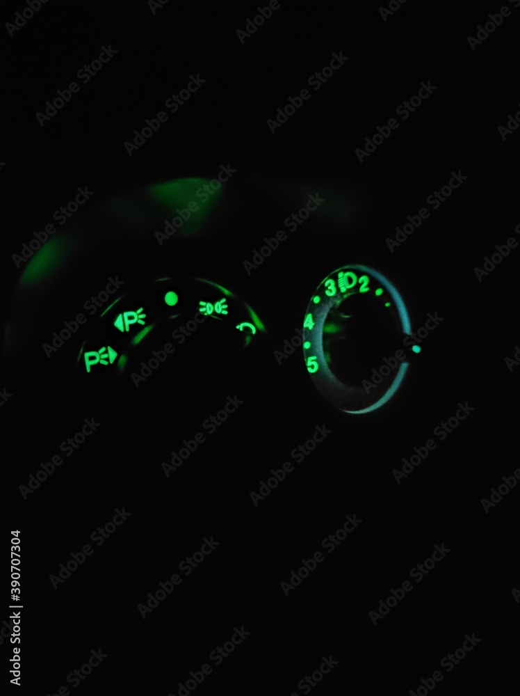 Glowing green dashboard in the car in the dark, on the panel there is a ...