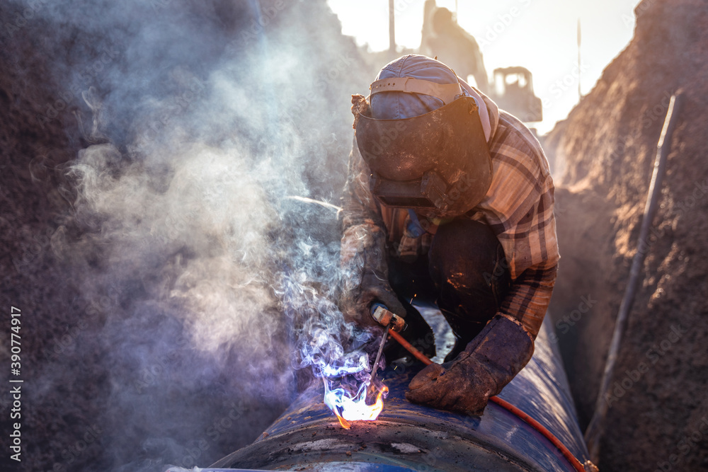 Pipe welding, Worker welding large water pipes in the road construction ...