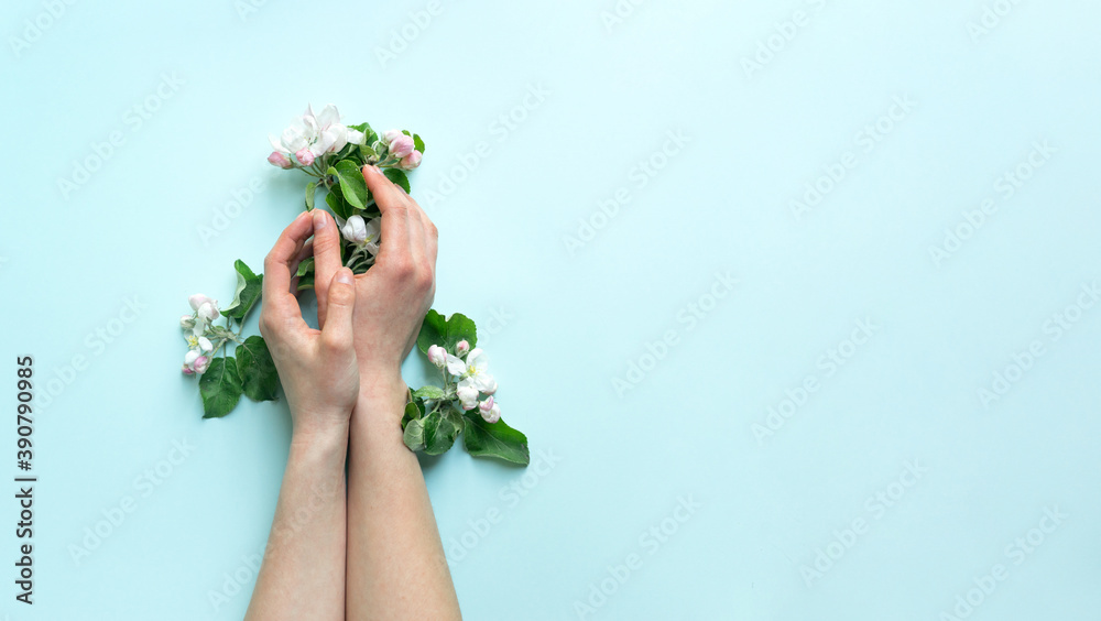 Beautiful female tender hands hold flowers on a bright sky blue ...