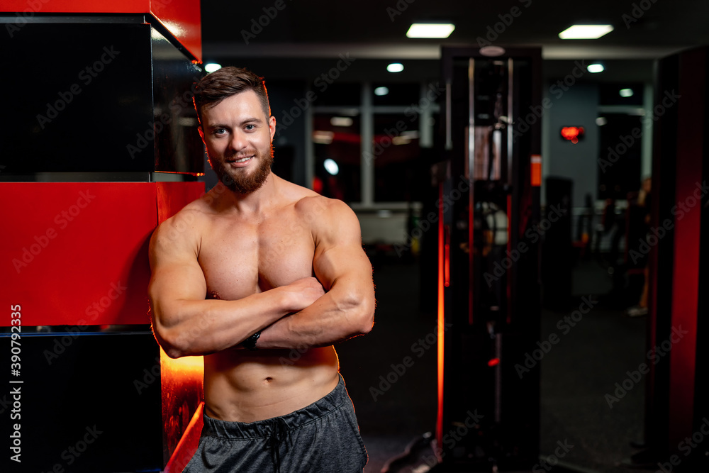 Athlete stands cross hands leaning to the column at gym. Shirtless ...