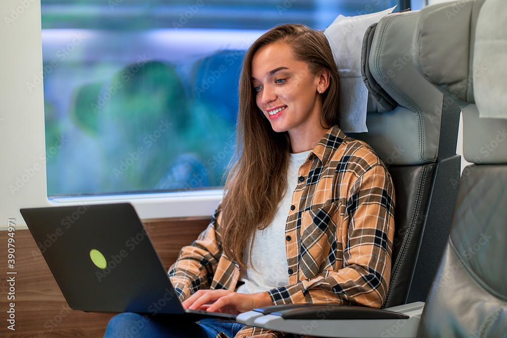 Young casual cute happy smiling smart woman passenger using a laptop ...